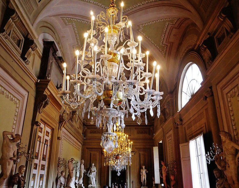Elaborate frescoed ceiling inside Palazzo Pitti showing classical figures and gold decorative elements
