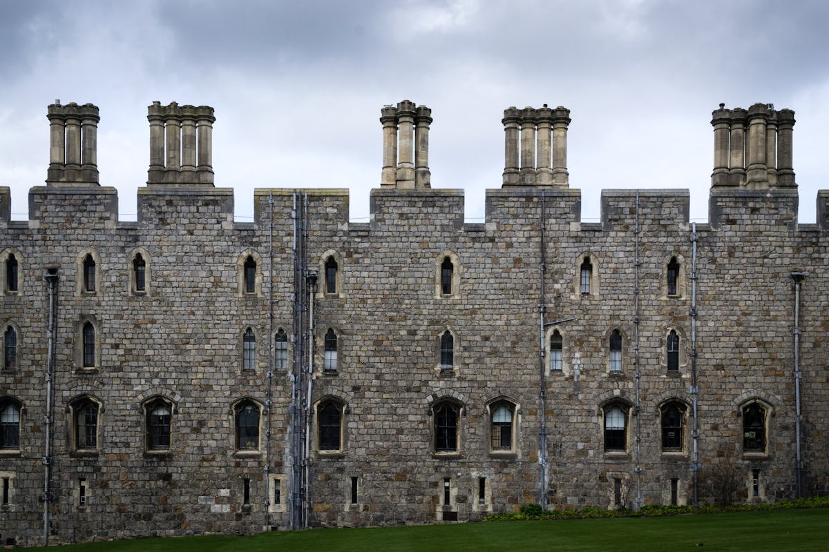 Stone facade of Windsor Castle against dramatic skies in England