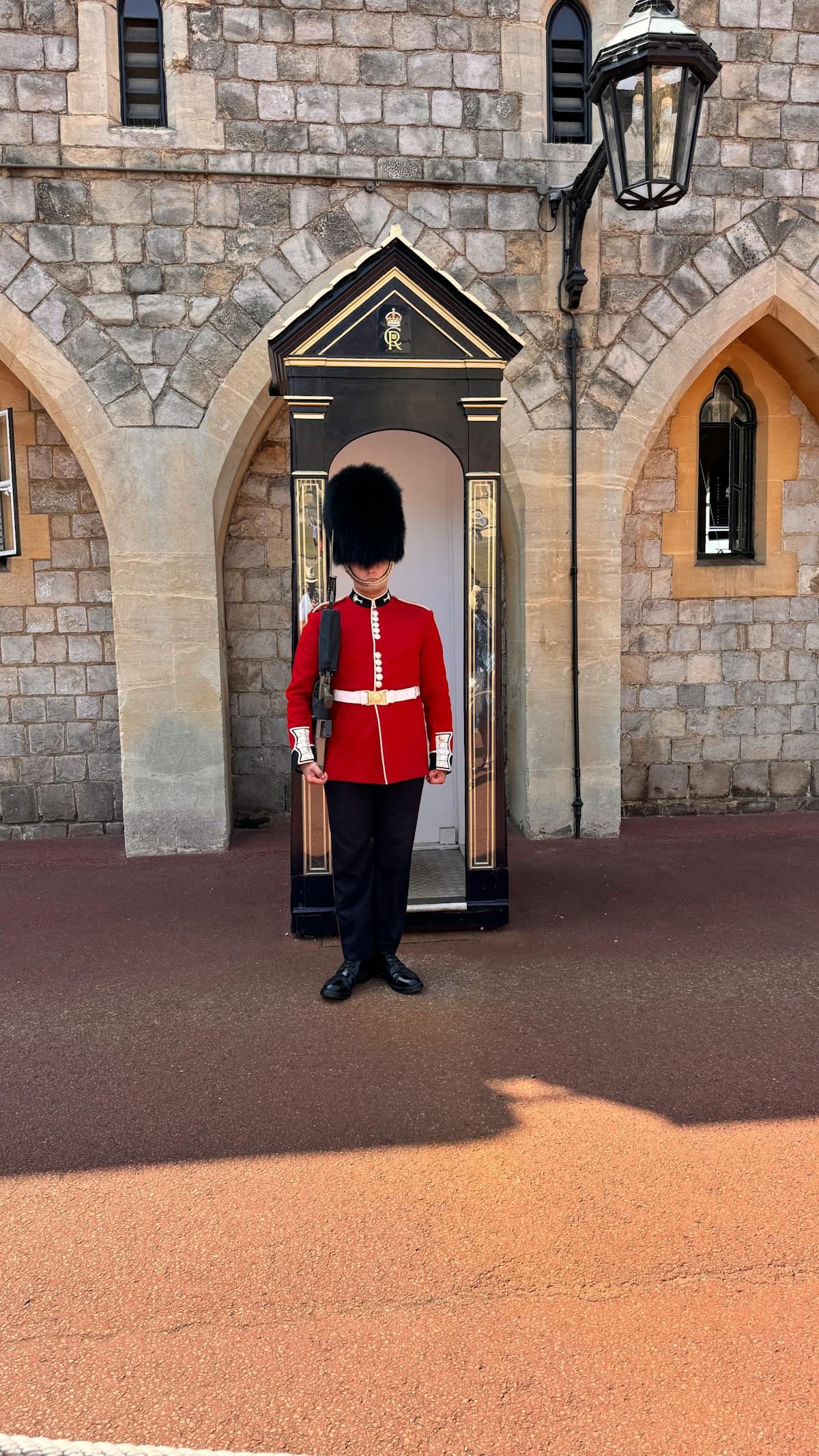 Guard in traditional red uniform standing watch outside Windsor Castle