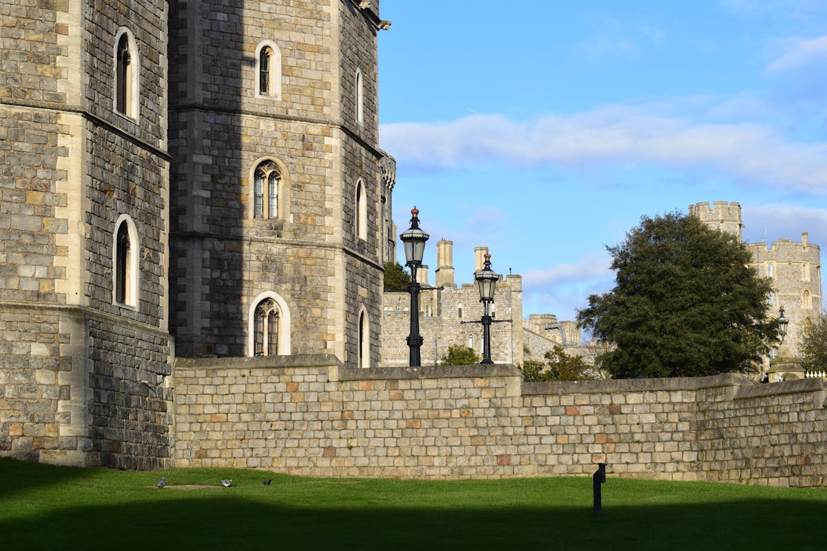 Ancient stone walls and towers of Windsor Castle under clear sky