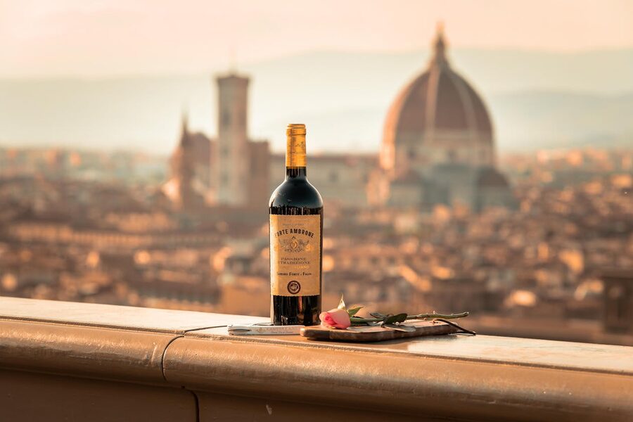 Bottle of Tuscan wine on a balcony with Florence Duomo cathedral visible in the evening light