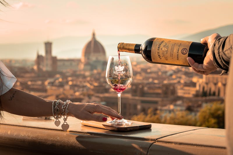 Wine being poured from a bottle with Florence Cathedral visible in the background
