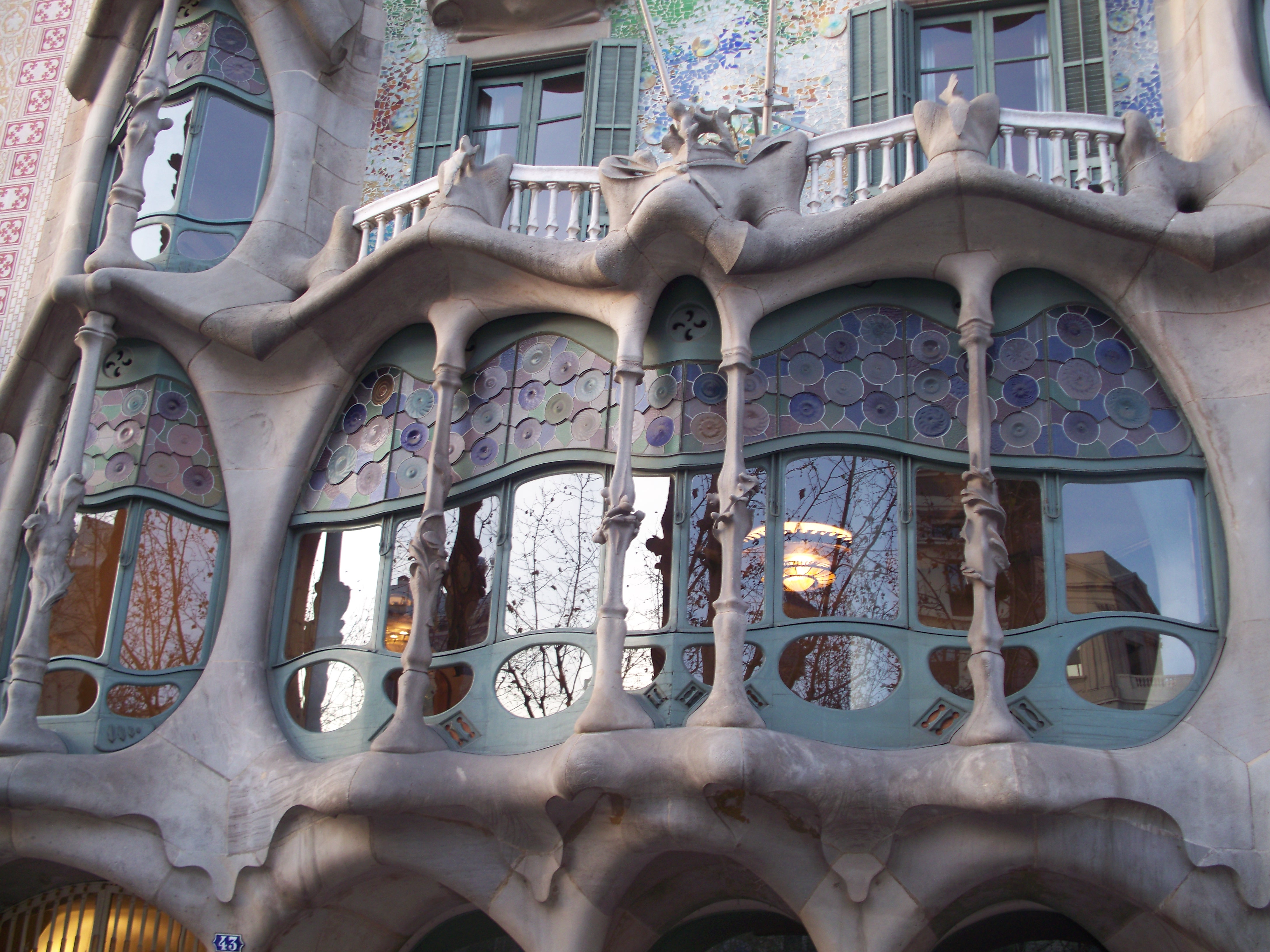 Close-up detail of Casa Batllo's colorful ceramic facade and organic window shapes