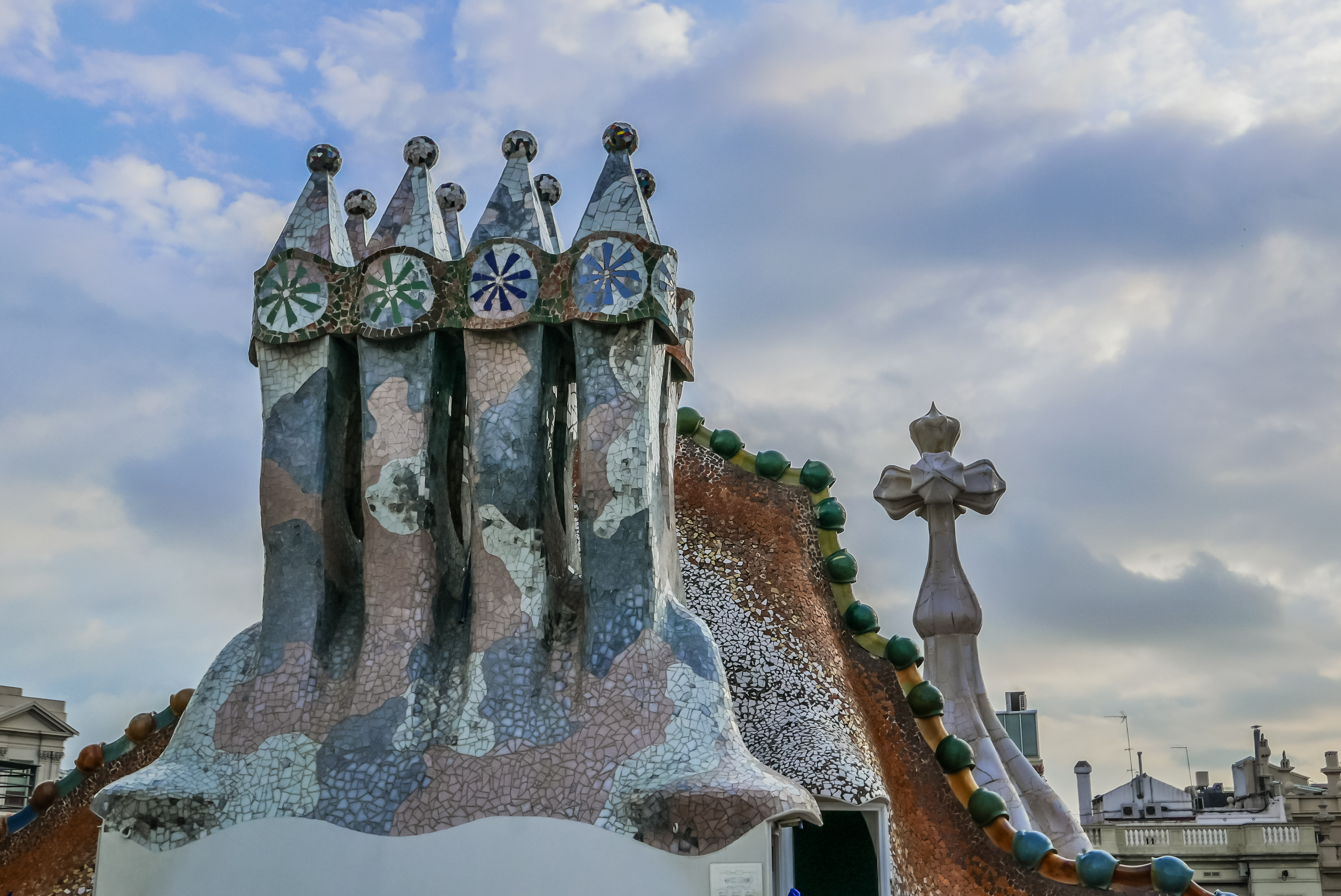 The dragon-spine rooftop and mosaic chimneys of Casa Batllo seen from above