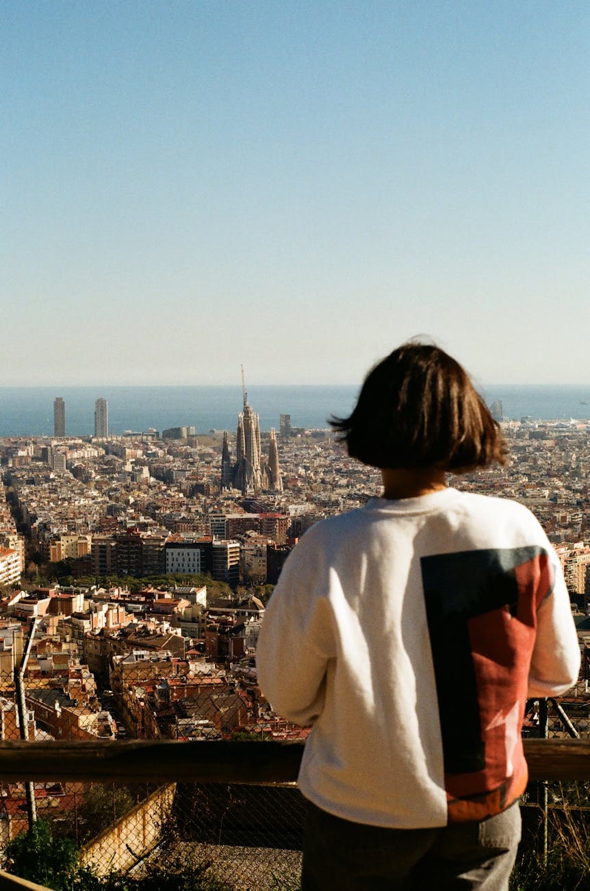 A visitor observing the Barcelona skyline with Sagrada Familia from an elevated viewpoint