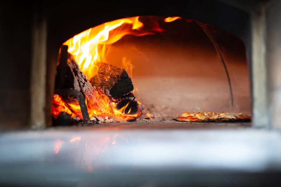 Authentic pizza baking with open flames in a traditional wood-fired oven