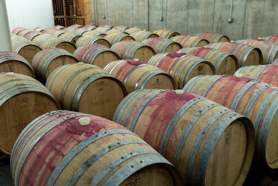 Neatly arranged wooden barrels in a winery aging room
