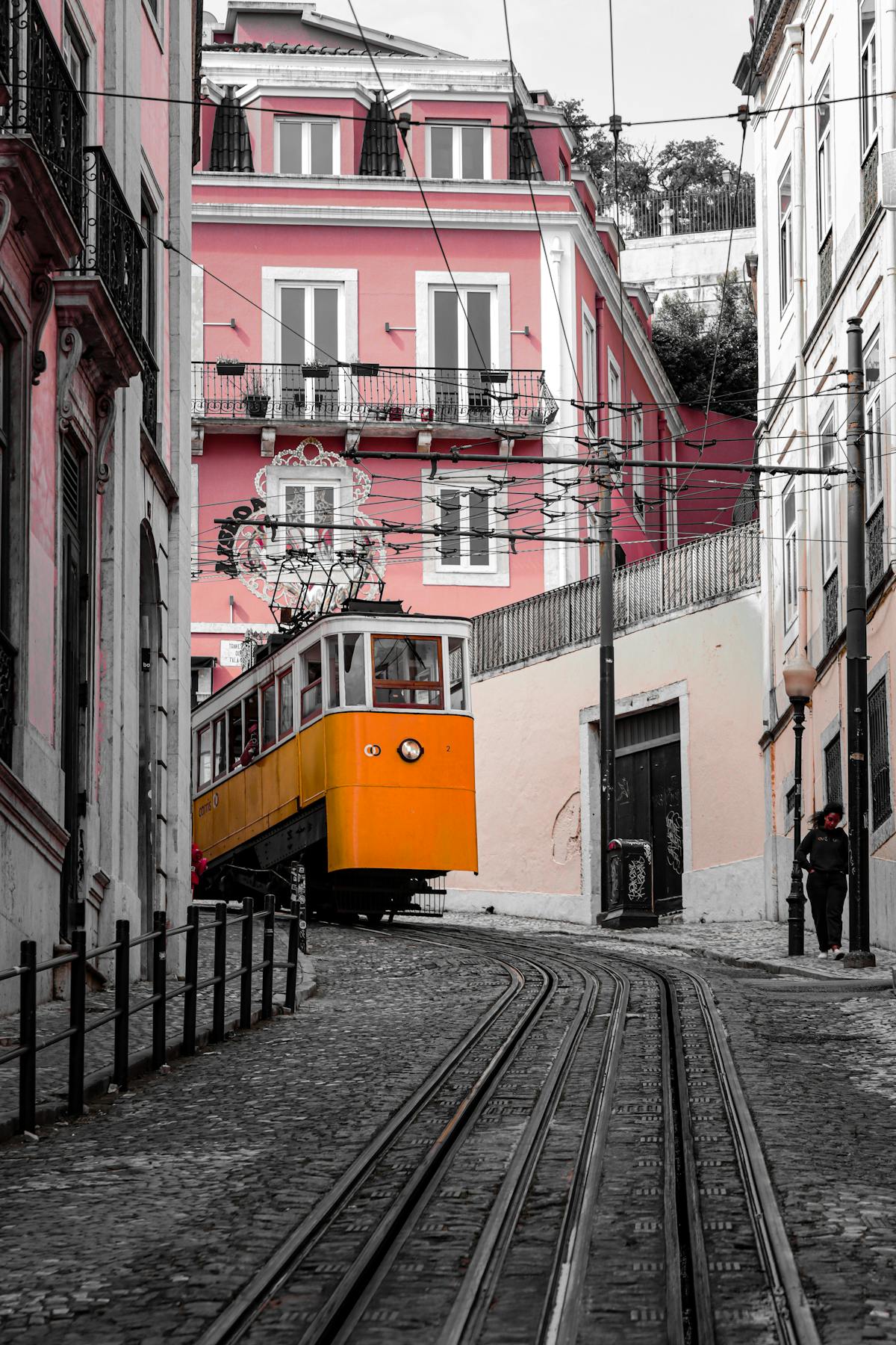 Yellow tram passing through a street of classic Portuguese architecture in Lisbon
